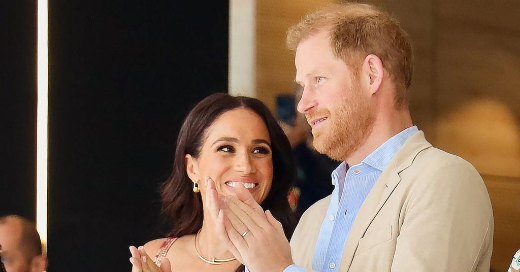Prince Harry Looks 'Grumpy' As Meghan Markle Steals The Spotlight